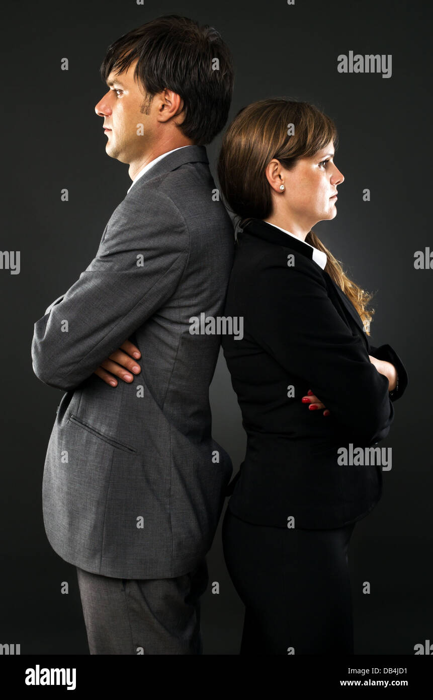 serious business couple standing back to back isolated on gray Stock ...