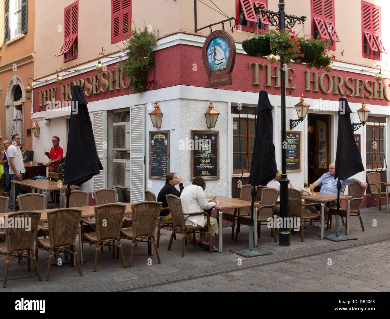 People sit outside in a British pub in the old town in Gibraltar Stock ...