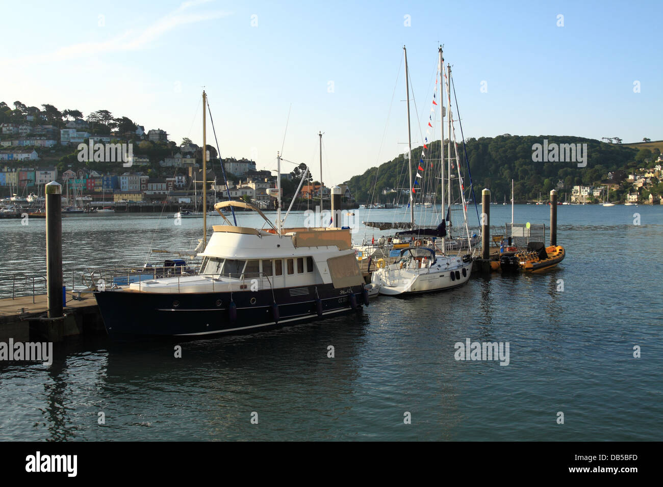 Motor Yacht and sailing yachts moored at jetties on the River Dart ...