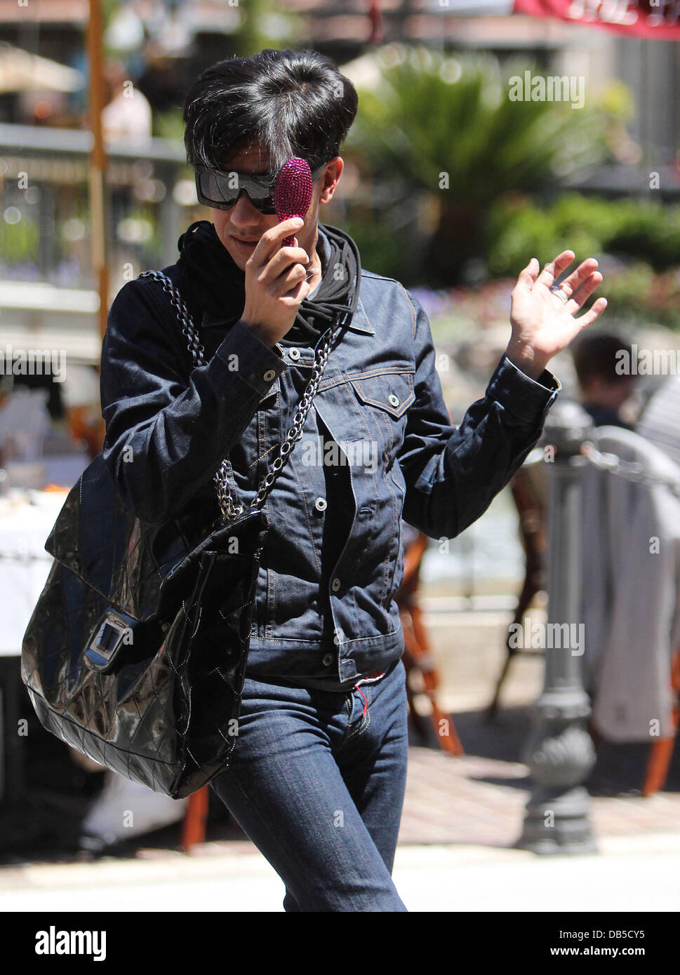 Bobby Trendy brushes his hair with a pink hair brush as he walks in The ...