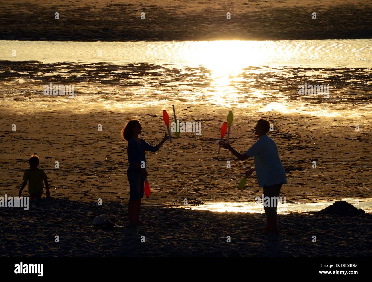 Two jugglers train in the light of the setting sun on the beach on Sylt ...