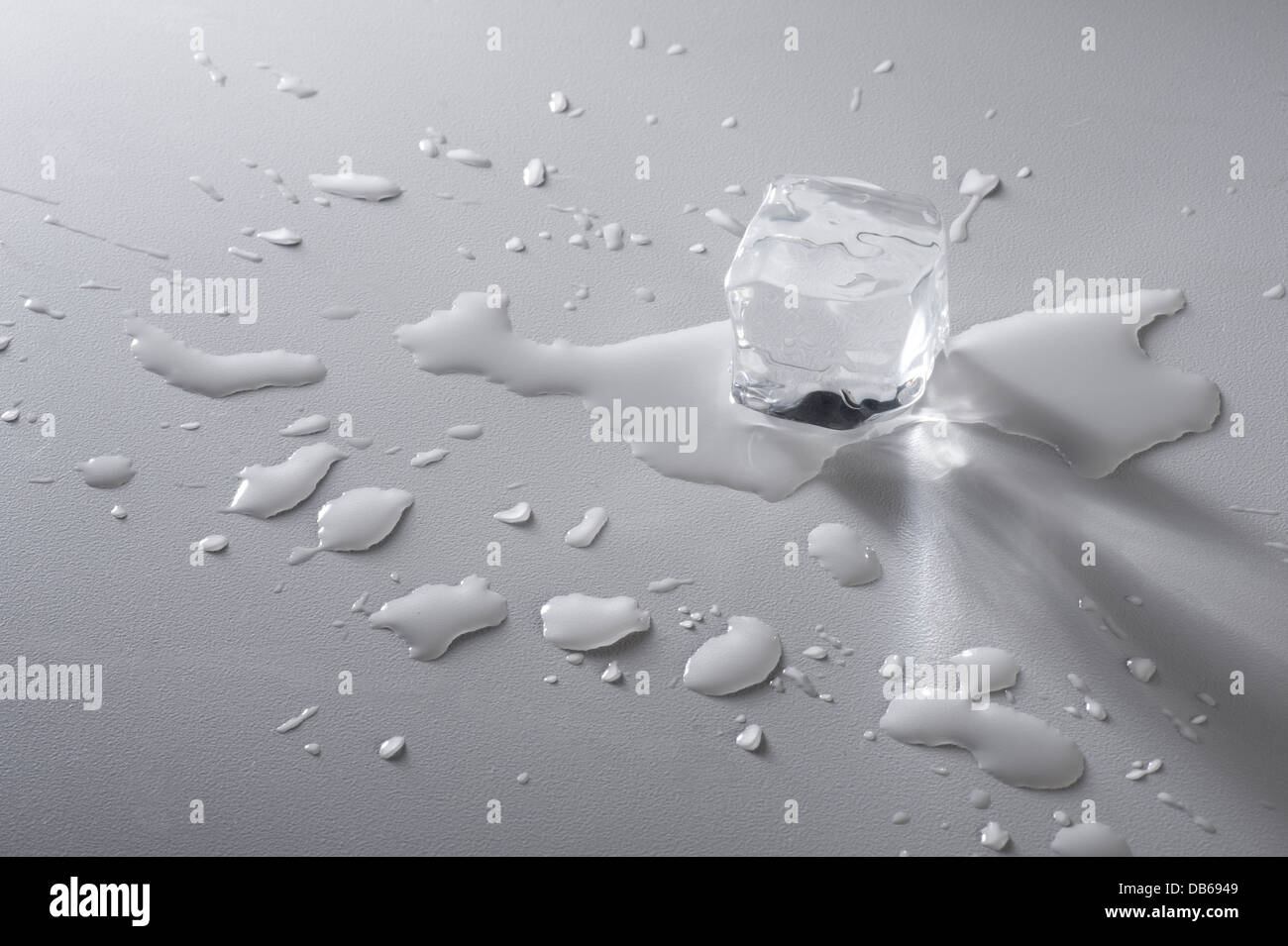Ice Cube Melting With Puddles Of Water Stock Photo - Alamy