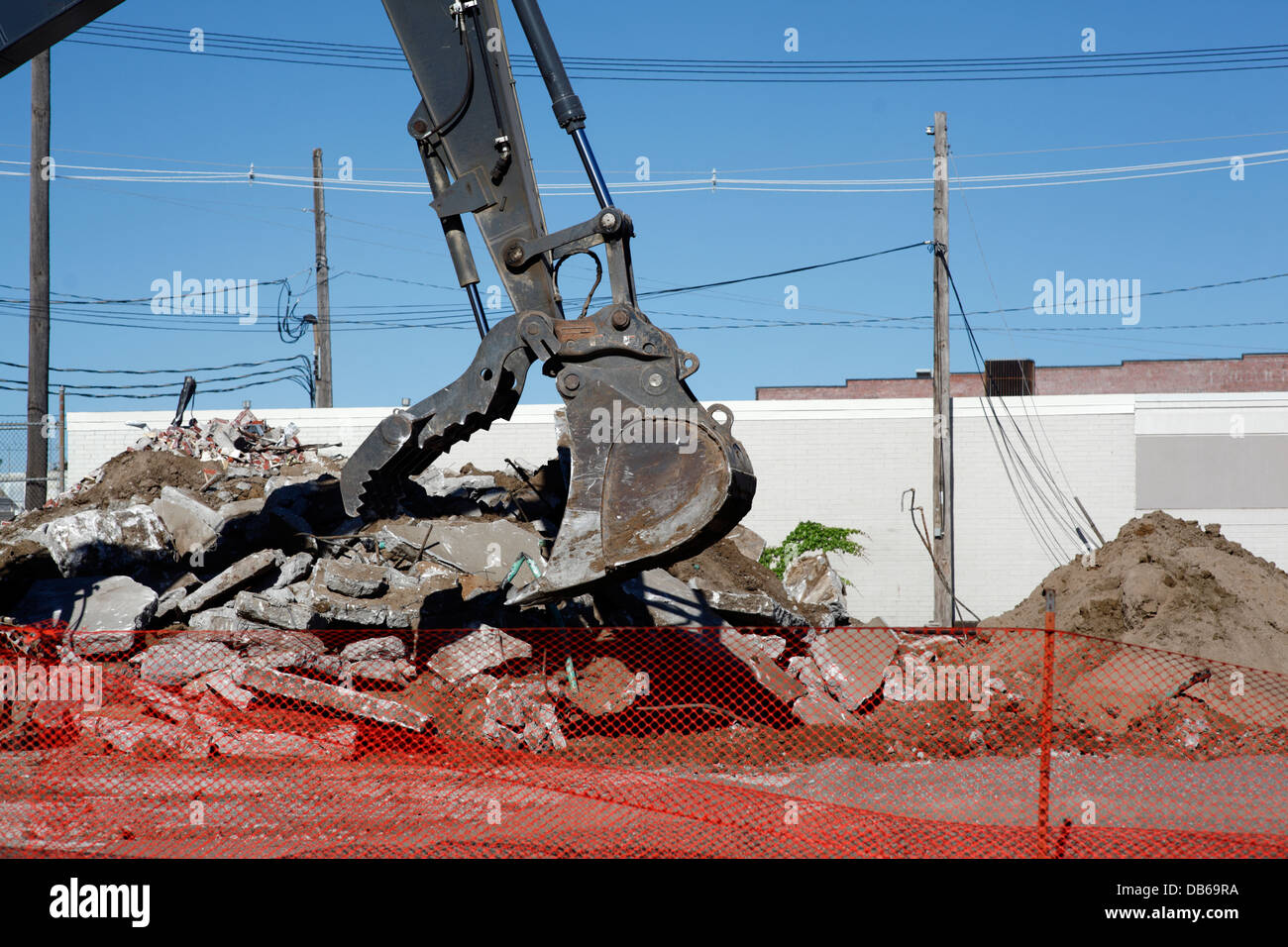 Excavator bucket next to concrete rubble pile Stock Photo - Alamy