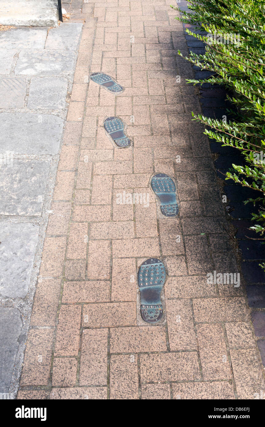Metal footprints embedded in brick pathway Stock Photo - Alamy