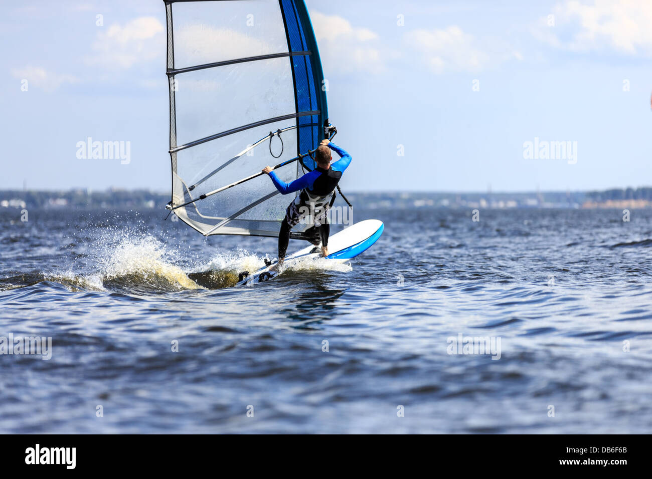 Rear view of a windsurfer passing by Stock Photo - Alamy
