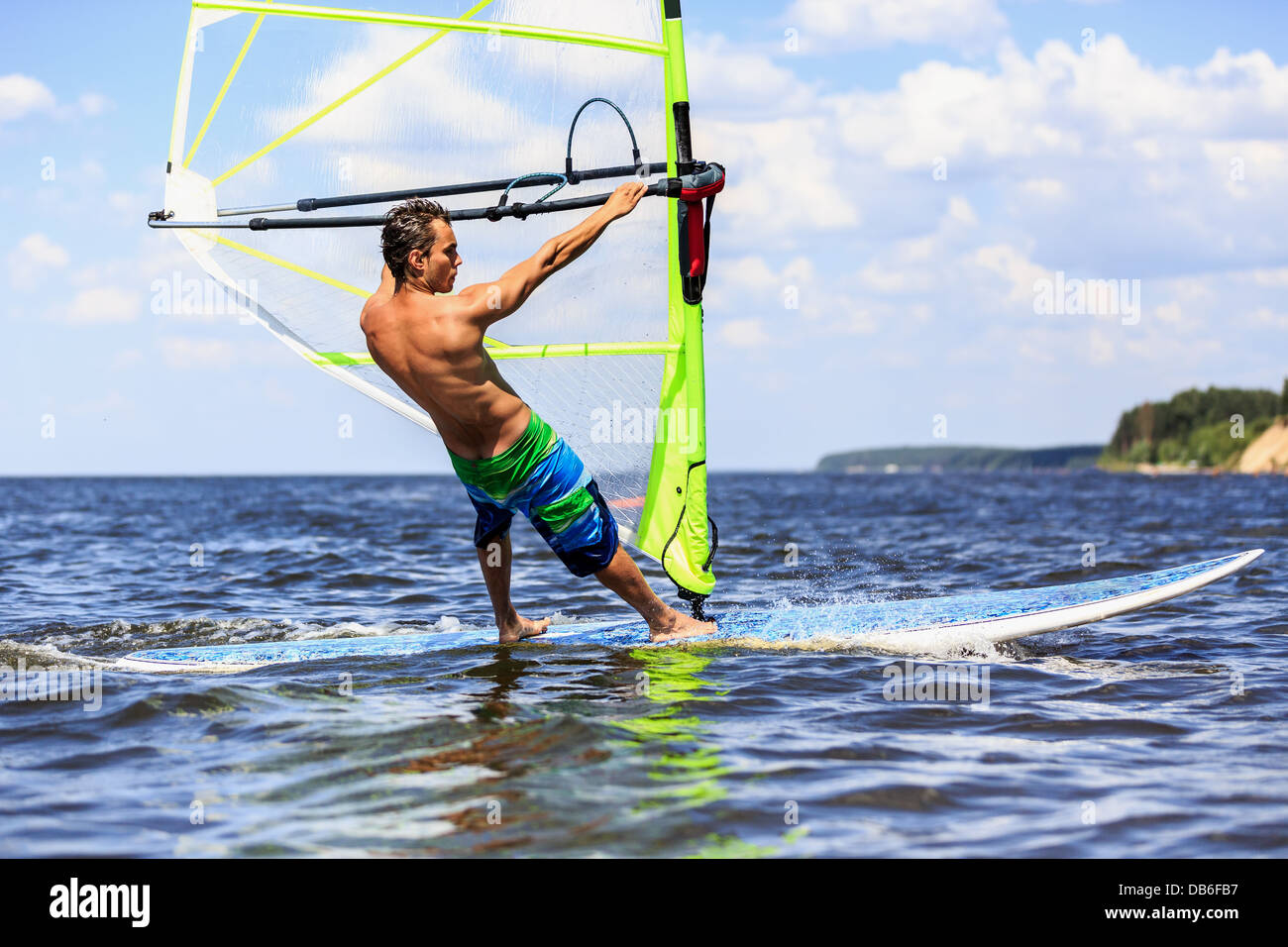 Side view of a windsurfer passing by Stock Photo - Alamy