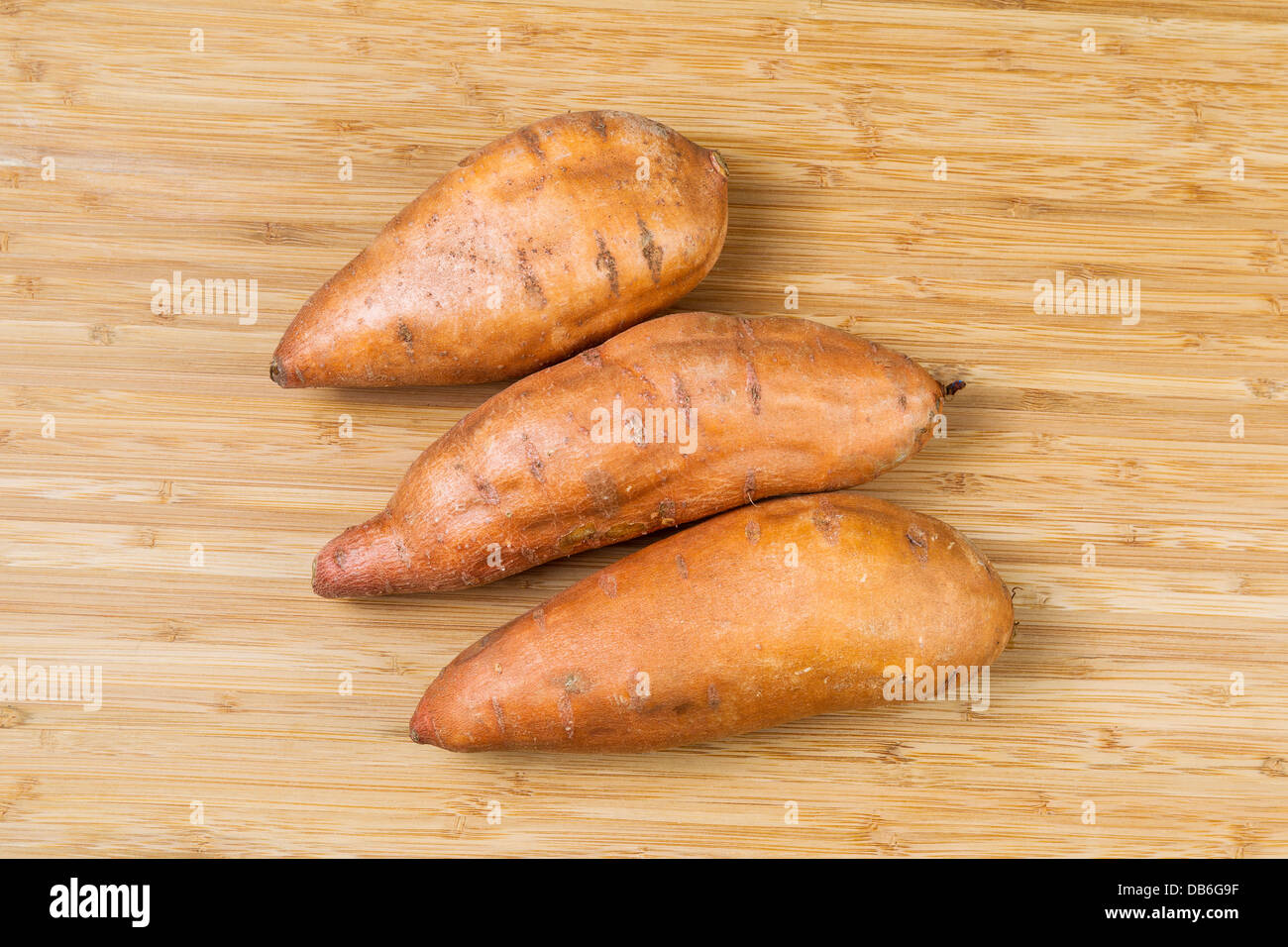Horizontal photo of three fully ripe yams on natural bamboo board Stock ...