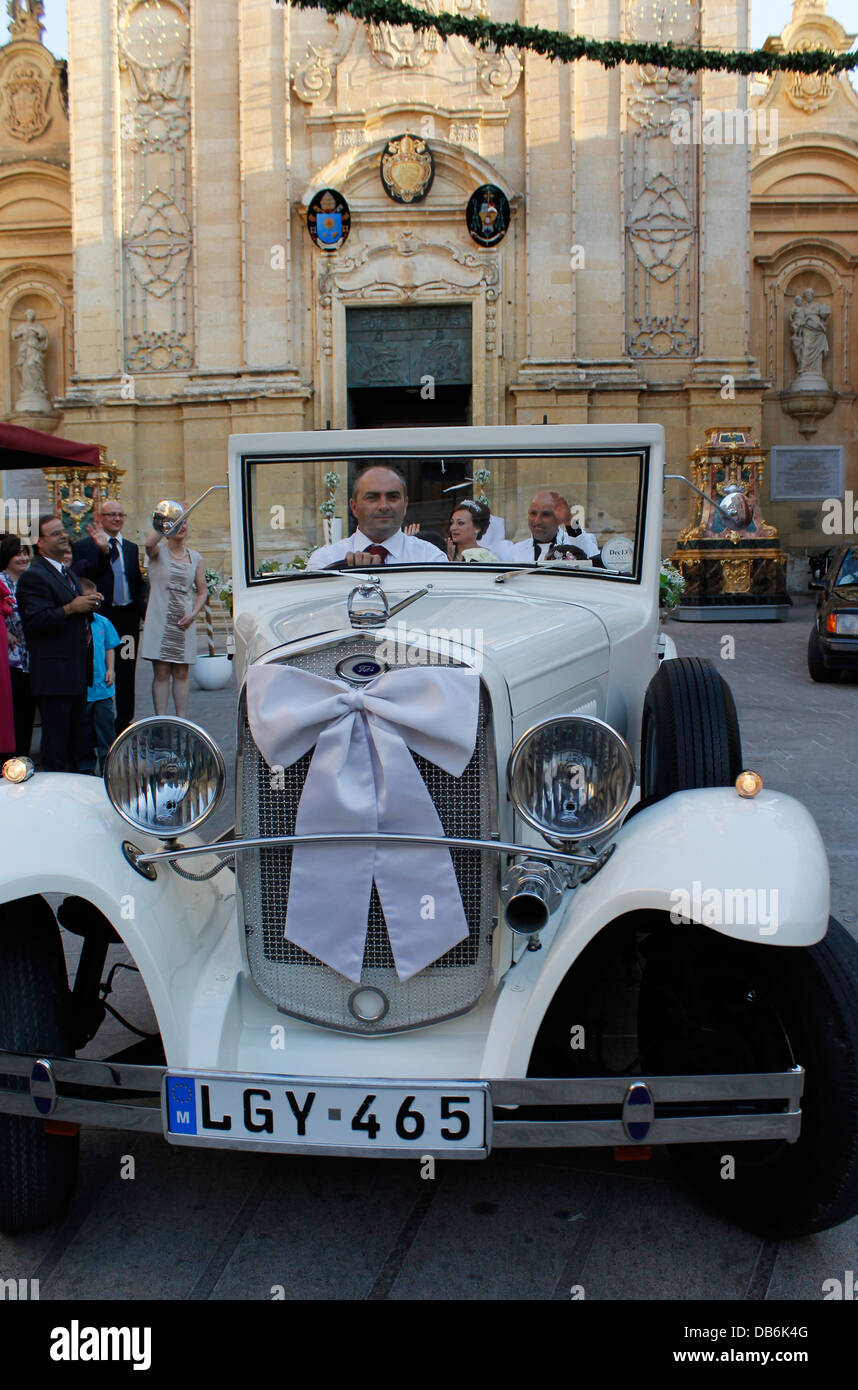 A limo driver with newlyweds in a 1930 Ford Model DeLuxe limousine ...