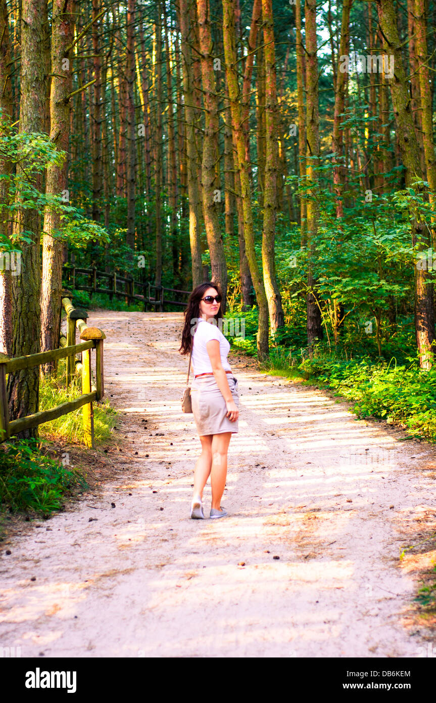 An image o girl walking through the forest pathway Stock Photo - Alamy