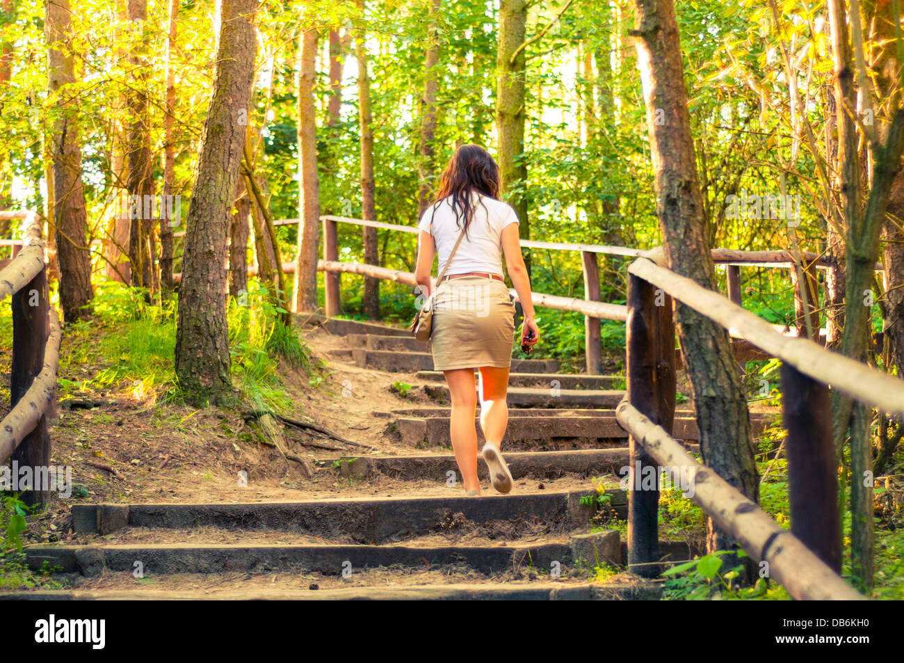 An image o girl walking through the forest pathway Stock Photo - Alamy