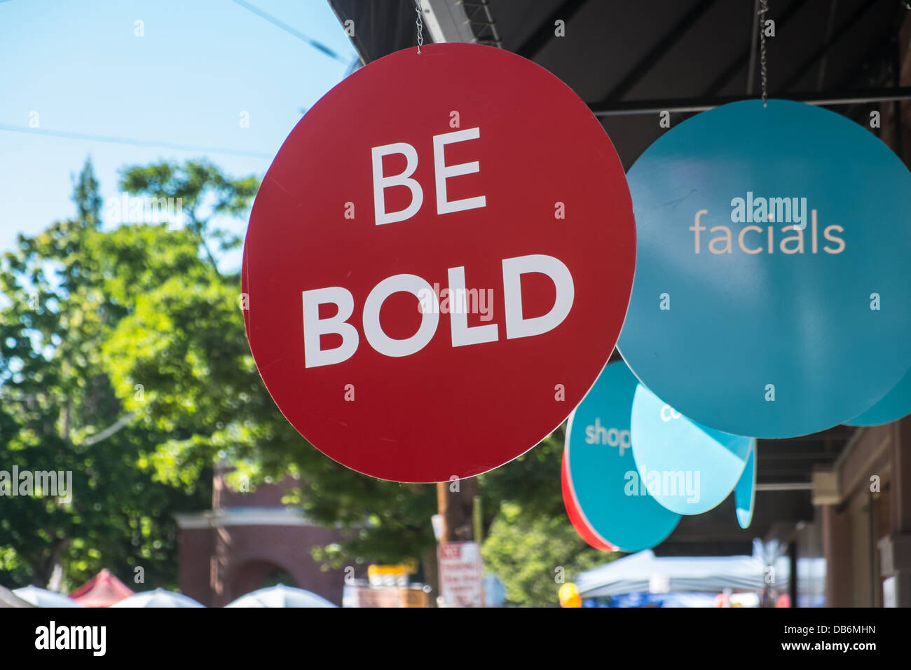 A hanging round store sign saying 'Be Bold' Stock Photo - Alamy