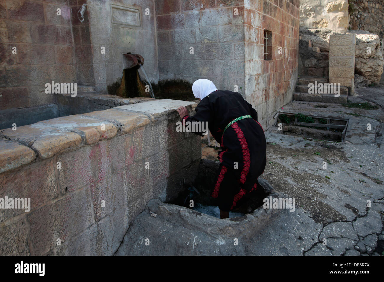 A Palestinian woman washing her feet at the ancient spring fountain in ...