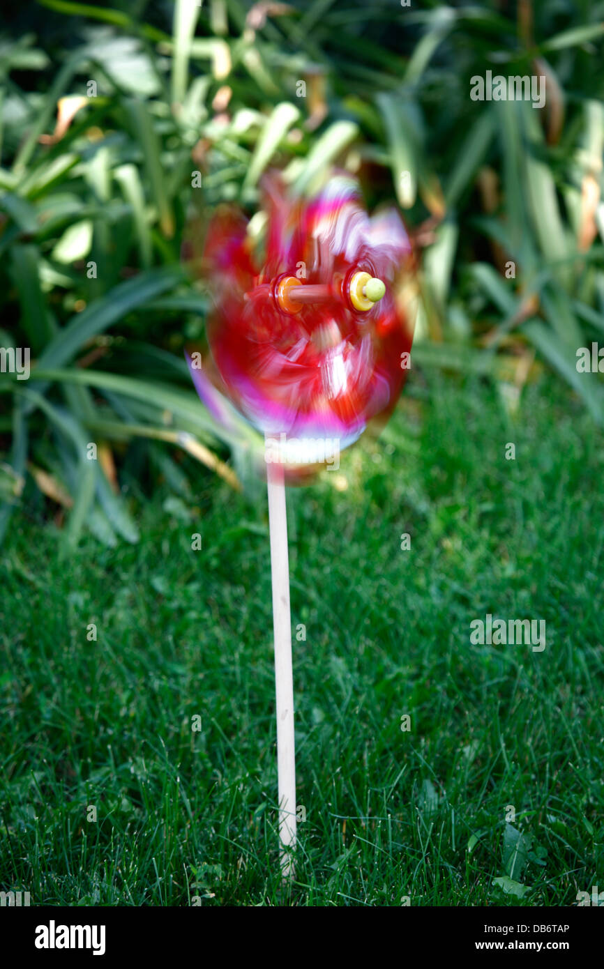 Spinning red pinwheel in lawn Stock Photo - Alamy