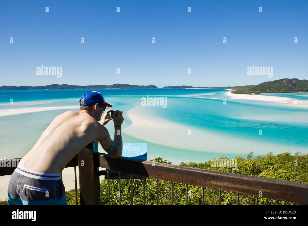 Tourist looking out over Hill Inlet from scenic viewpoint. Whitsunday ...