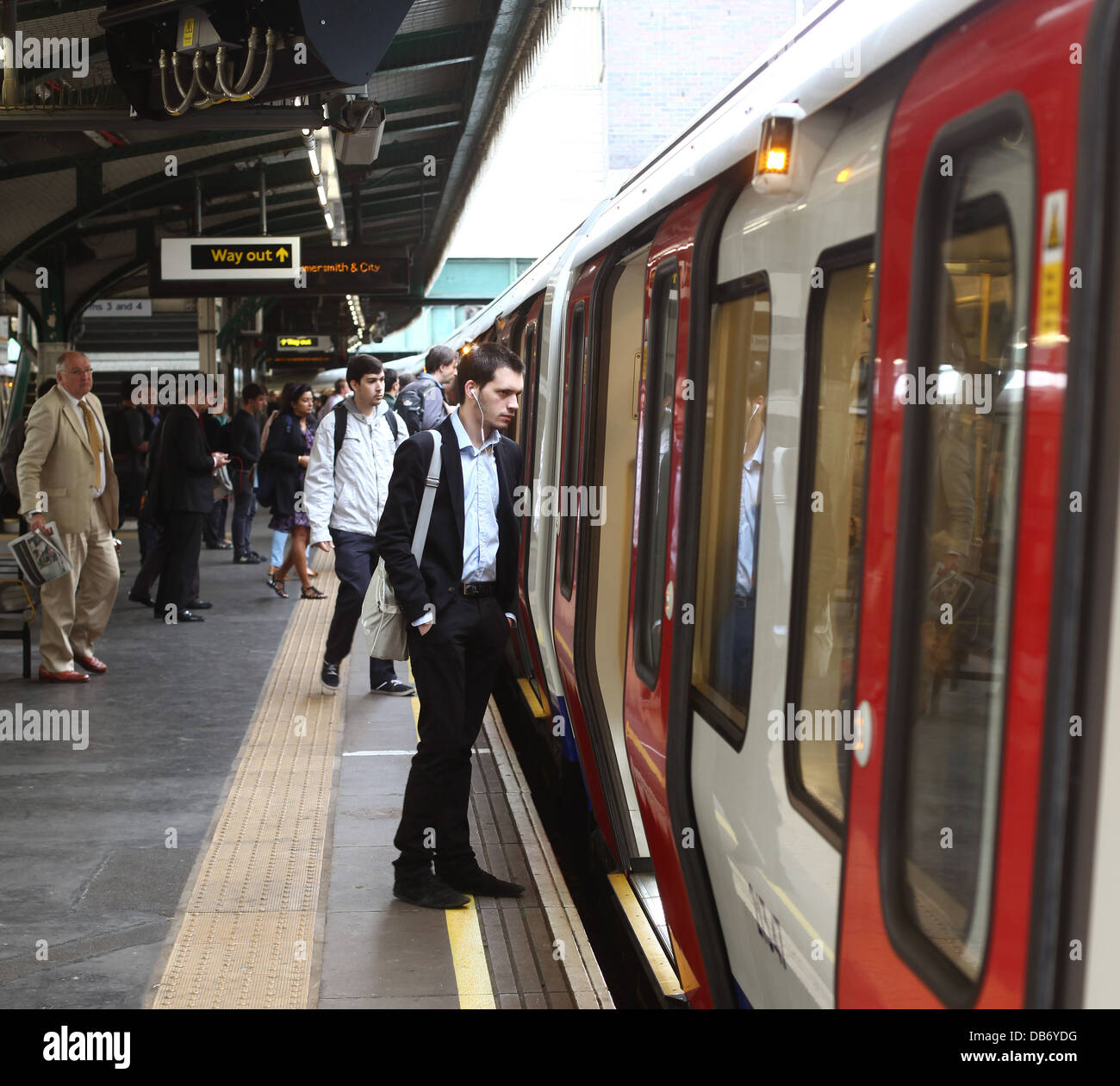 Young man getting into a London Underground train on his daily commute ...
