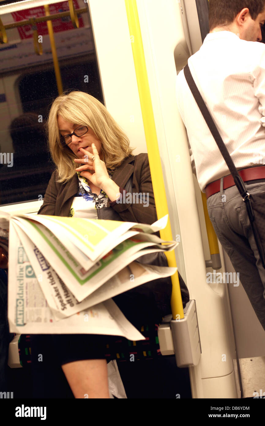 Reading Metro, woman on the London Underground reading a copy of the ...