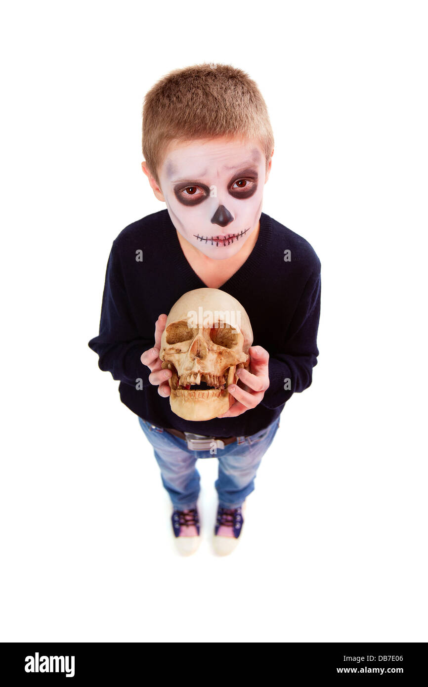 Photo of eerie boy with human skull looking at camera Stock Photo - Alamy