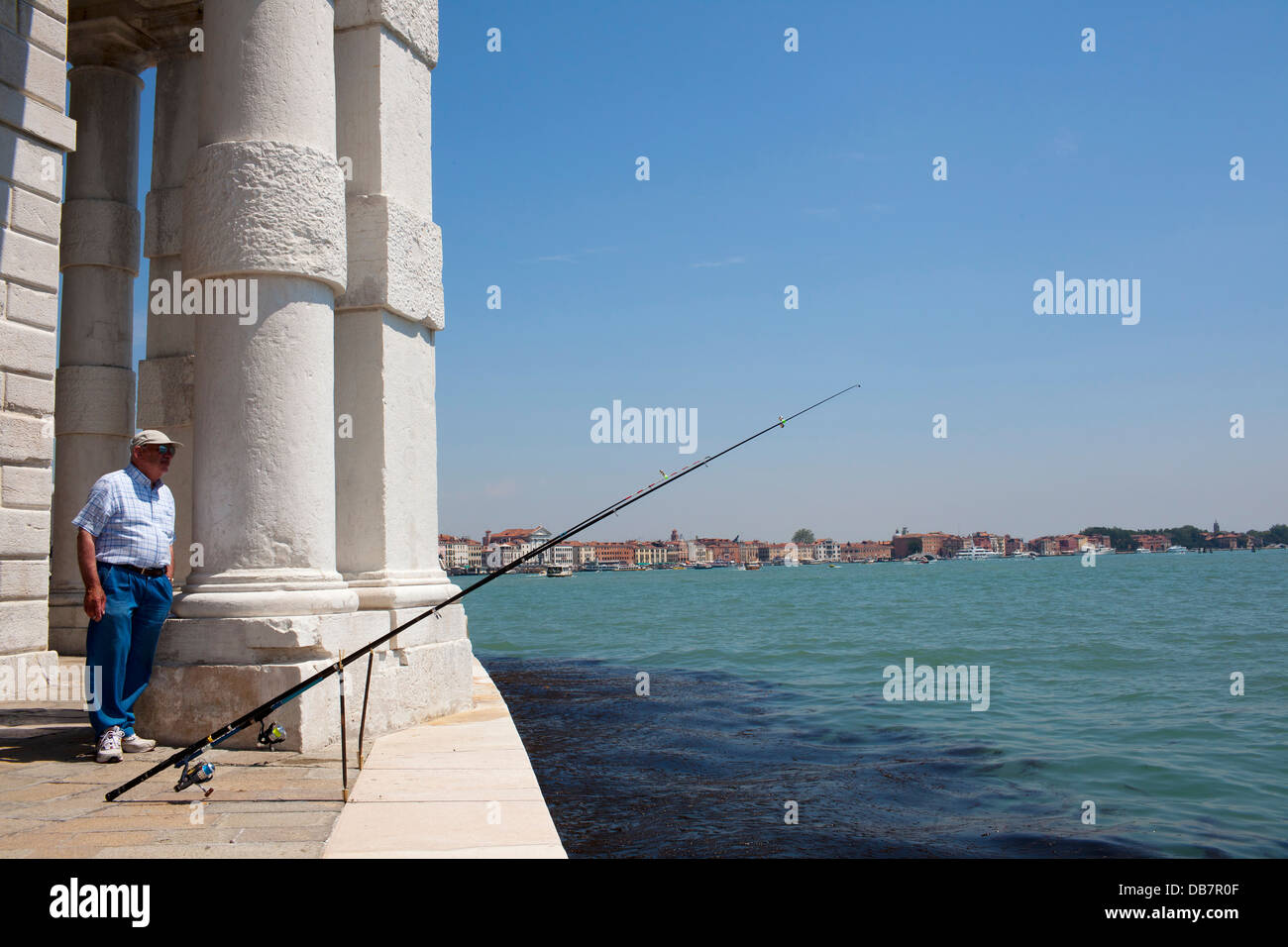A man stands by his fishing rod in Venice, Italy Stock Photo - Alamy