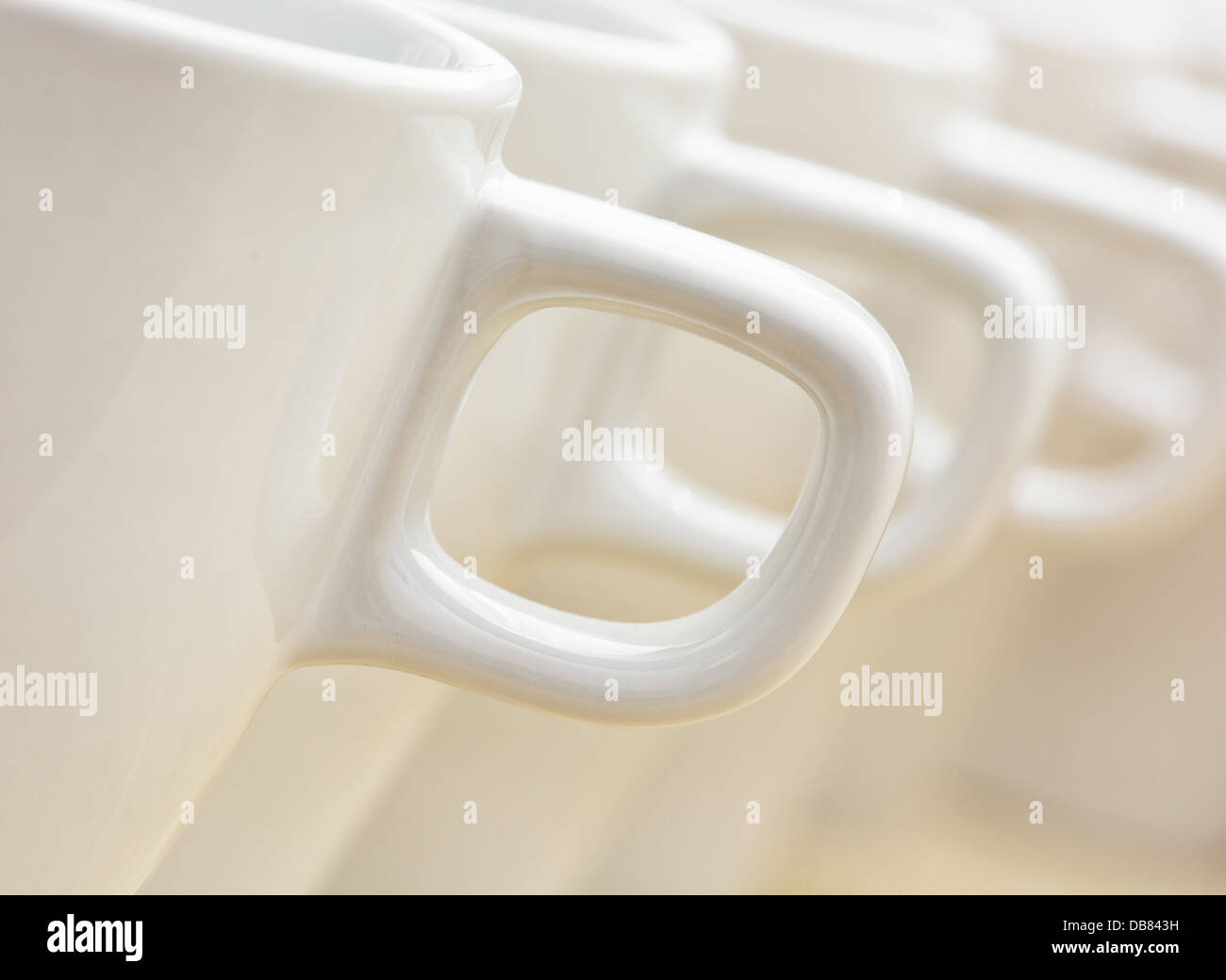 Row of white cups with handles Stock Photo - Alamy
