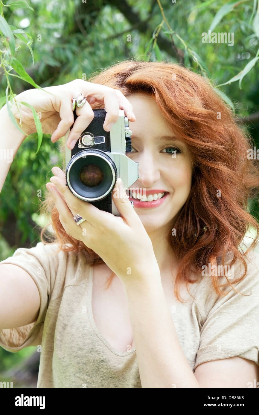 Young woman photographing with an old analogue photo film camera Stock ...