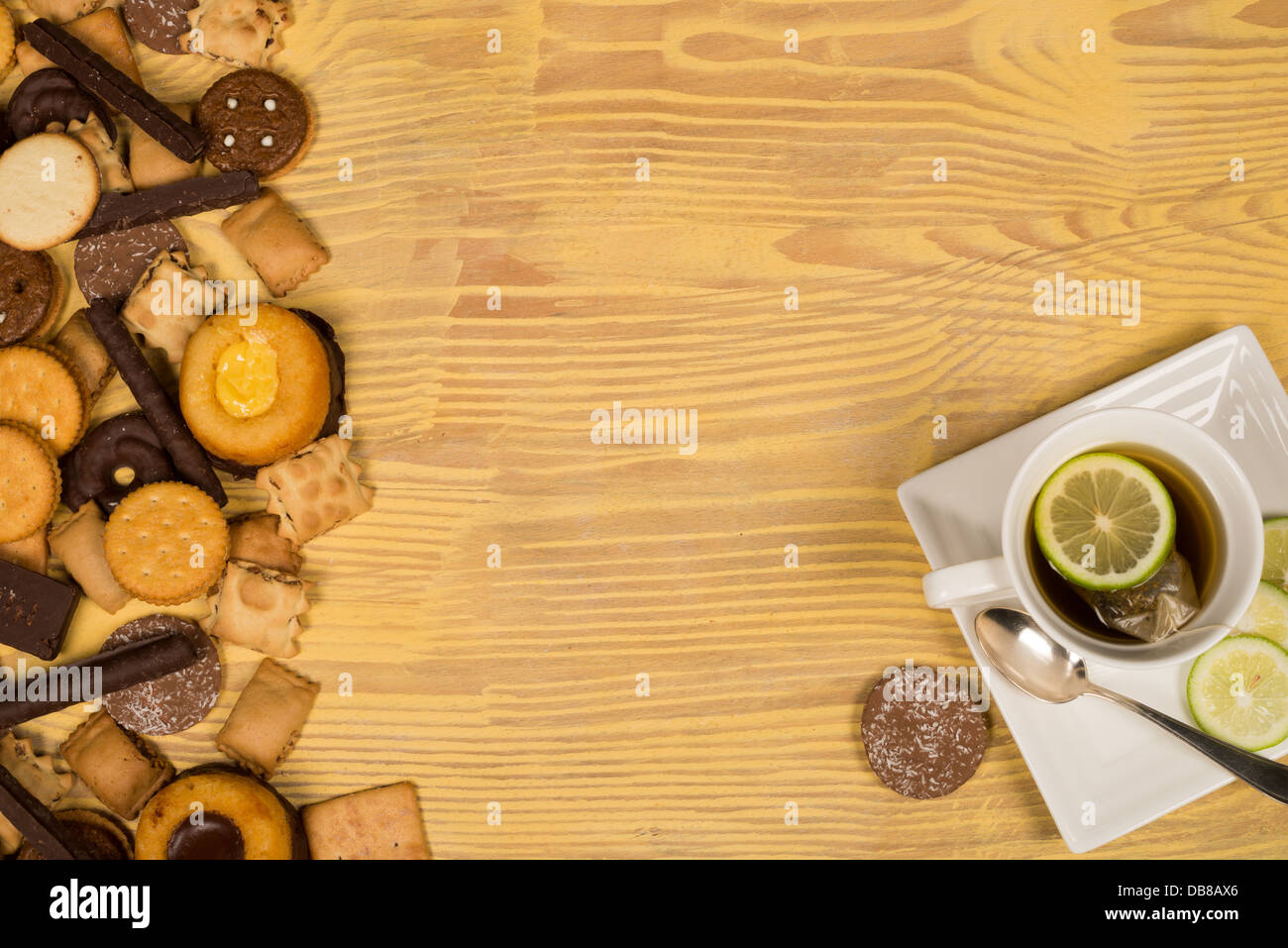 Assorted tea time cookies next to a cup of tea Stock Photo - Alamy
