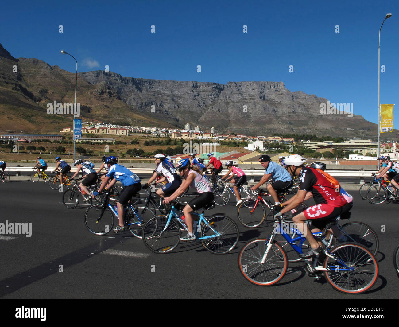cyclists pedal near start race Table Mountain in back Argus Cycle Tour ...