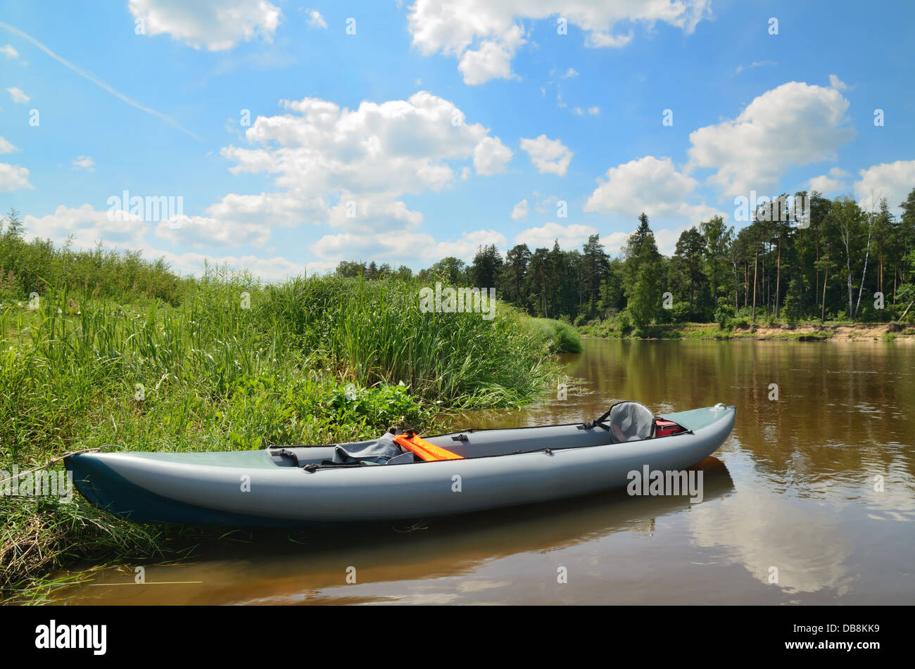 Gray kayak on the shore of the Neman river in Belarus with wood ...