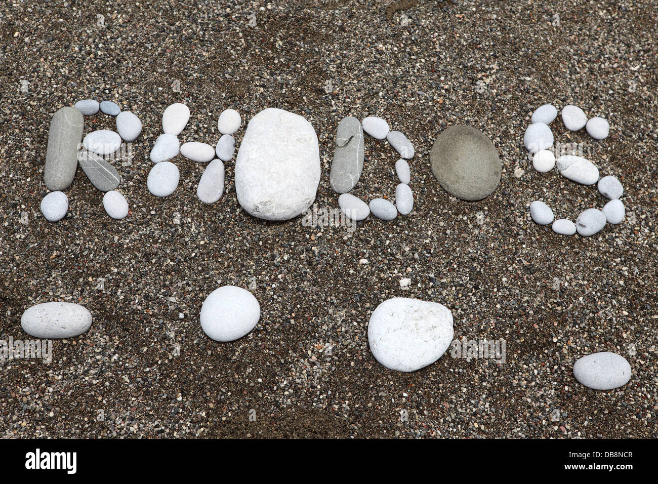 "Rhodos" says a sign written in stones on a beach at Lindos, Rhodes ...