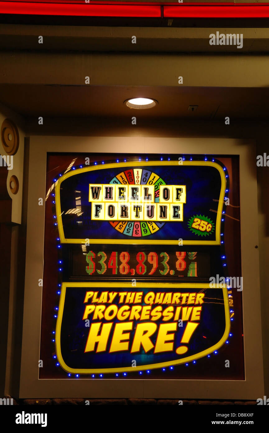 Night portrait illuminated 'Wheel of Fortune' slot machine advert in ...