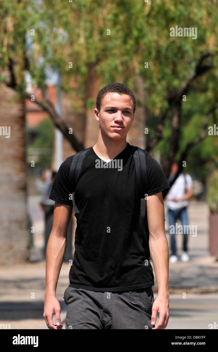 A young man walks on a college campus Stock Photo - Alamy