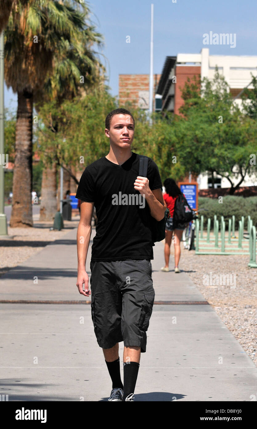 A young man walks on a college campus Stock Photo - Alamy