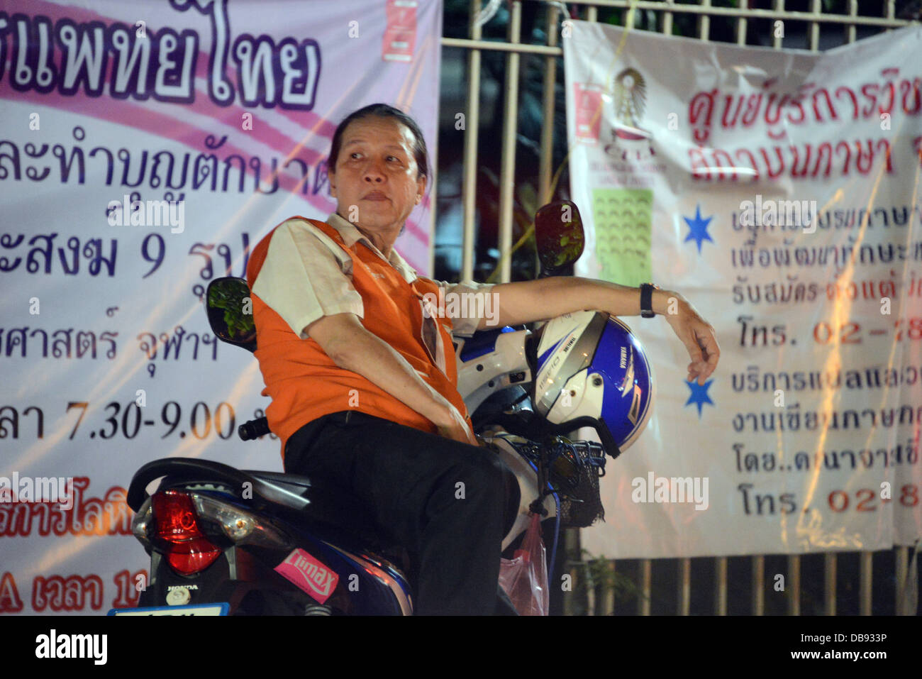Thai taxi driver female bike rider leaning on motorbike with helmet on ...