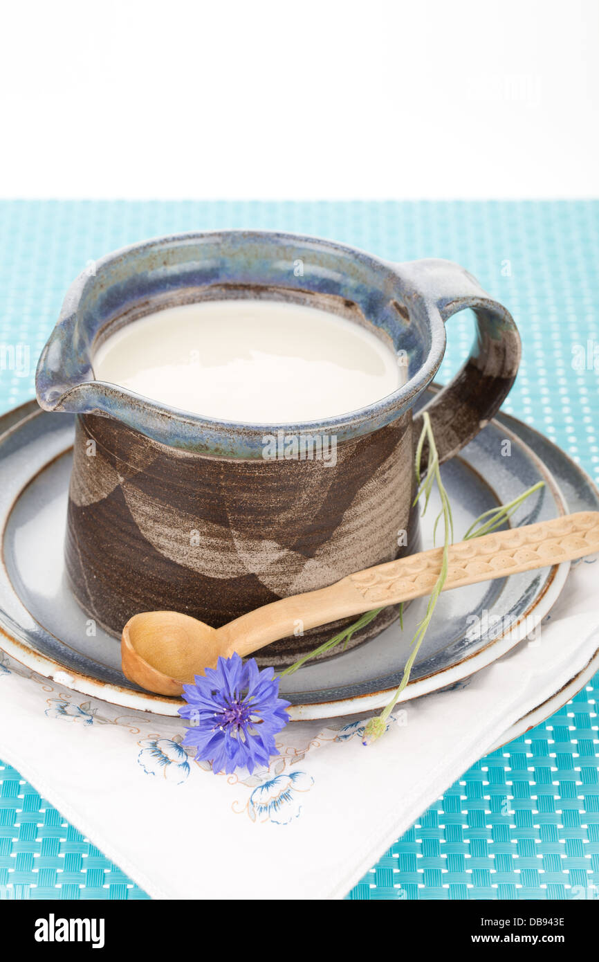 Kefir in argil jug with wooden spoon on rustic plate Stock Photo - Alamy