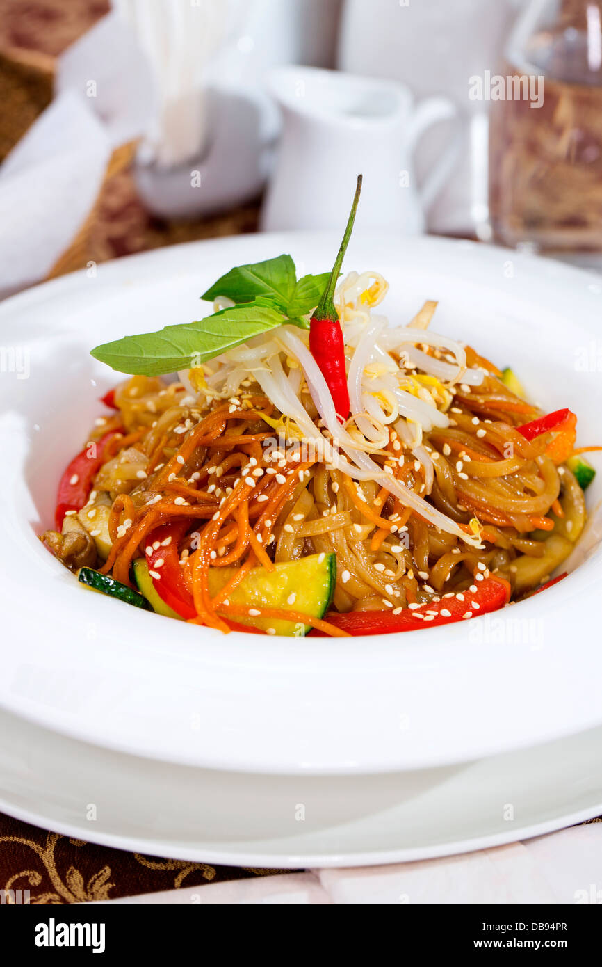 Rice spaghetti with vegetables on a white plate in a restaurant Stock ...