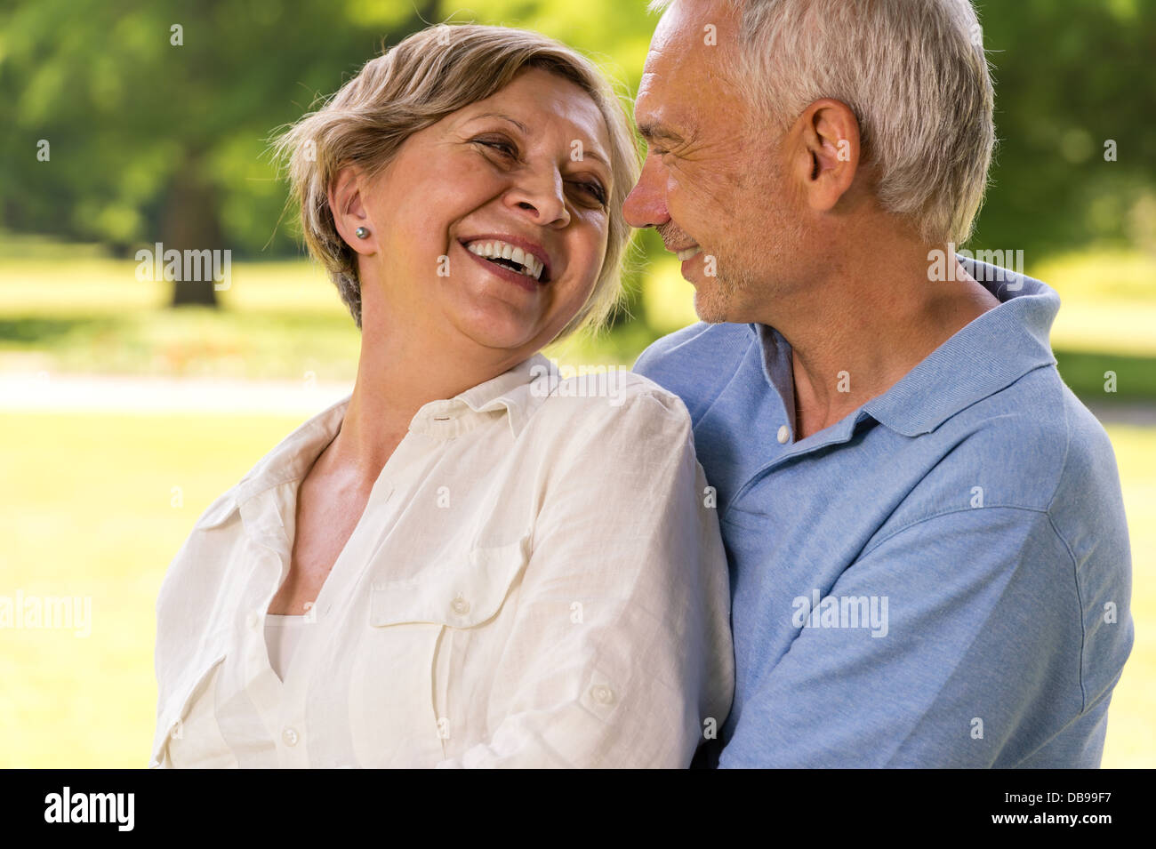Happy retirement senior couple hugging and smiling at each other Stock ...