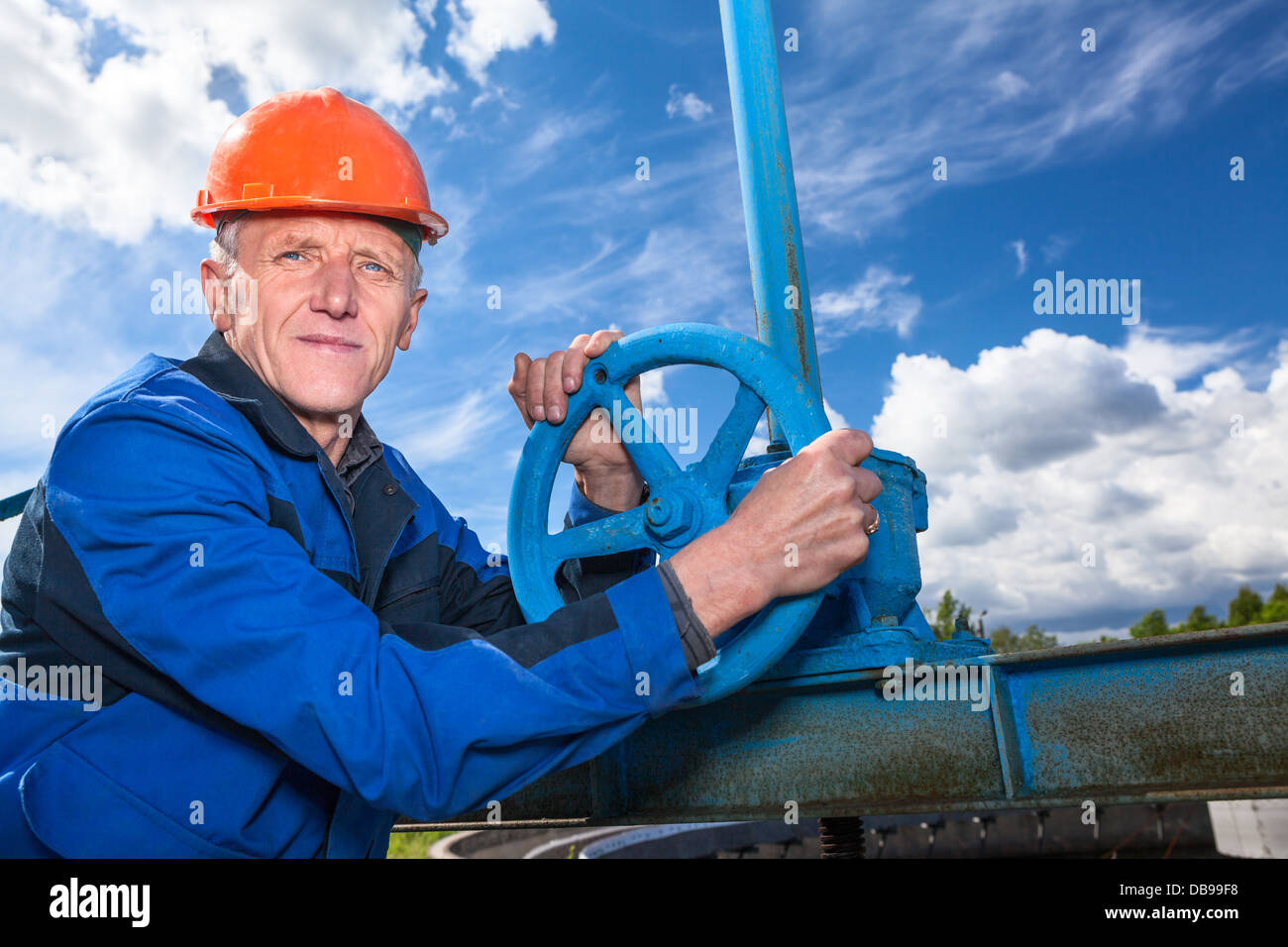 Worker turning valve at water treatment plant hi-res stock photography ...