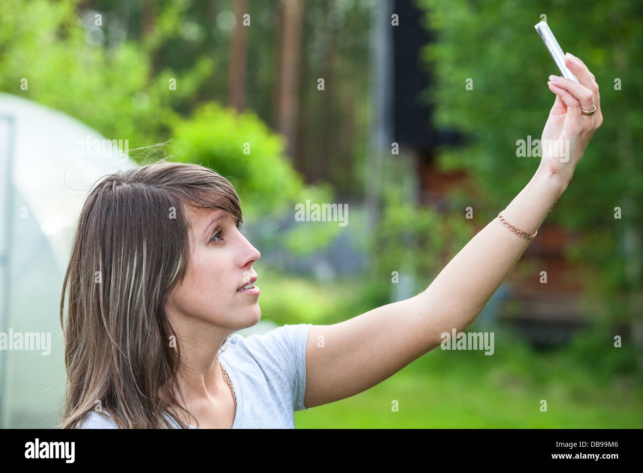 Young woman holding cell phone up for good connection Stock Photo - Alamy