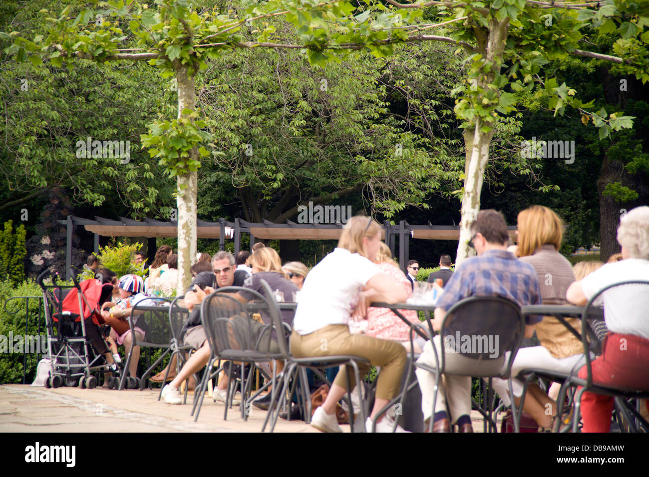 outdoor cafe families seated eating drinking enjoying the summer day in ...