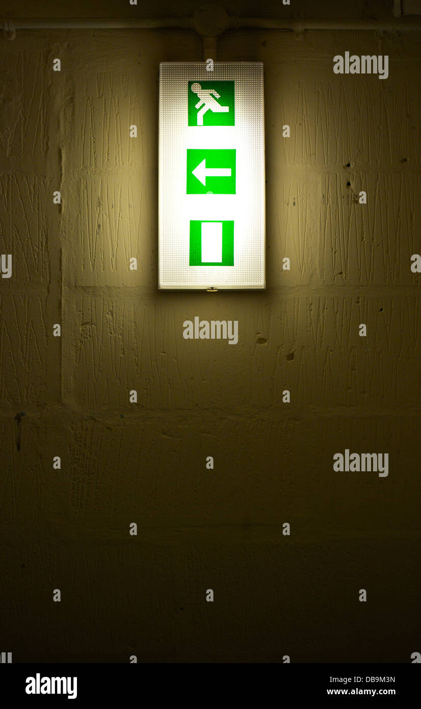 An illuminated exit sign in a dark and dingy basement corridor Stock ...