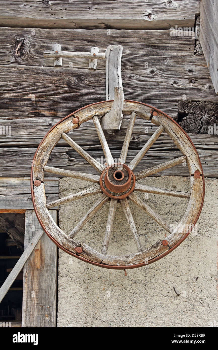 Old wooden wheel hanging on a wooden wall of the barn Stock Photo - Alamy