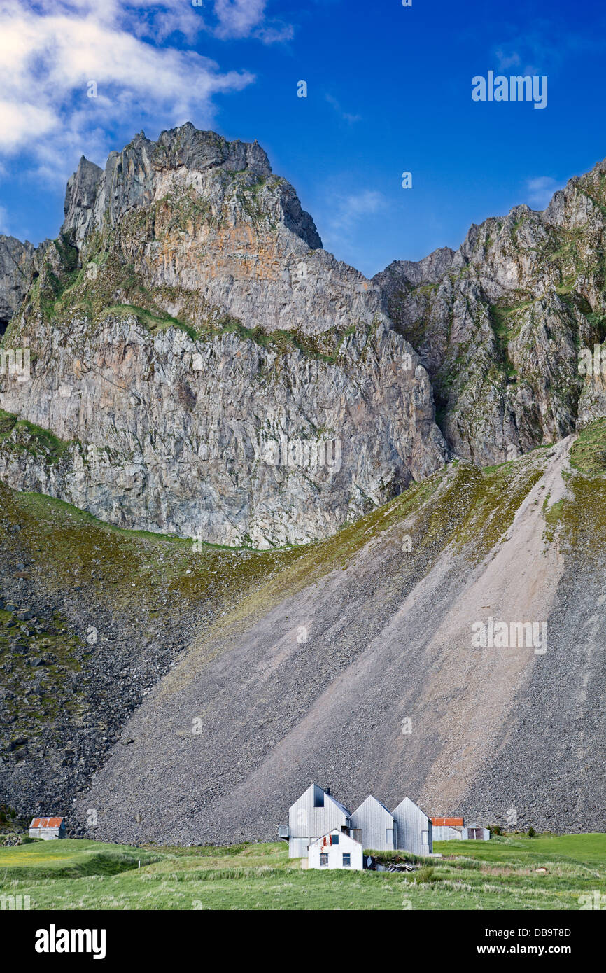 Two small houses at the bottom of a steep hill. A majestic landscape in ...