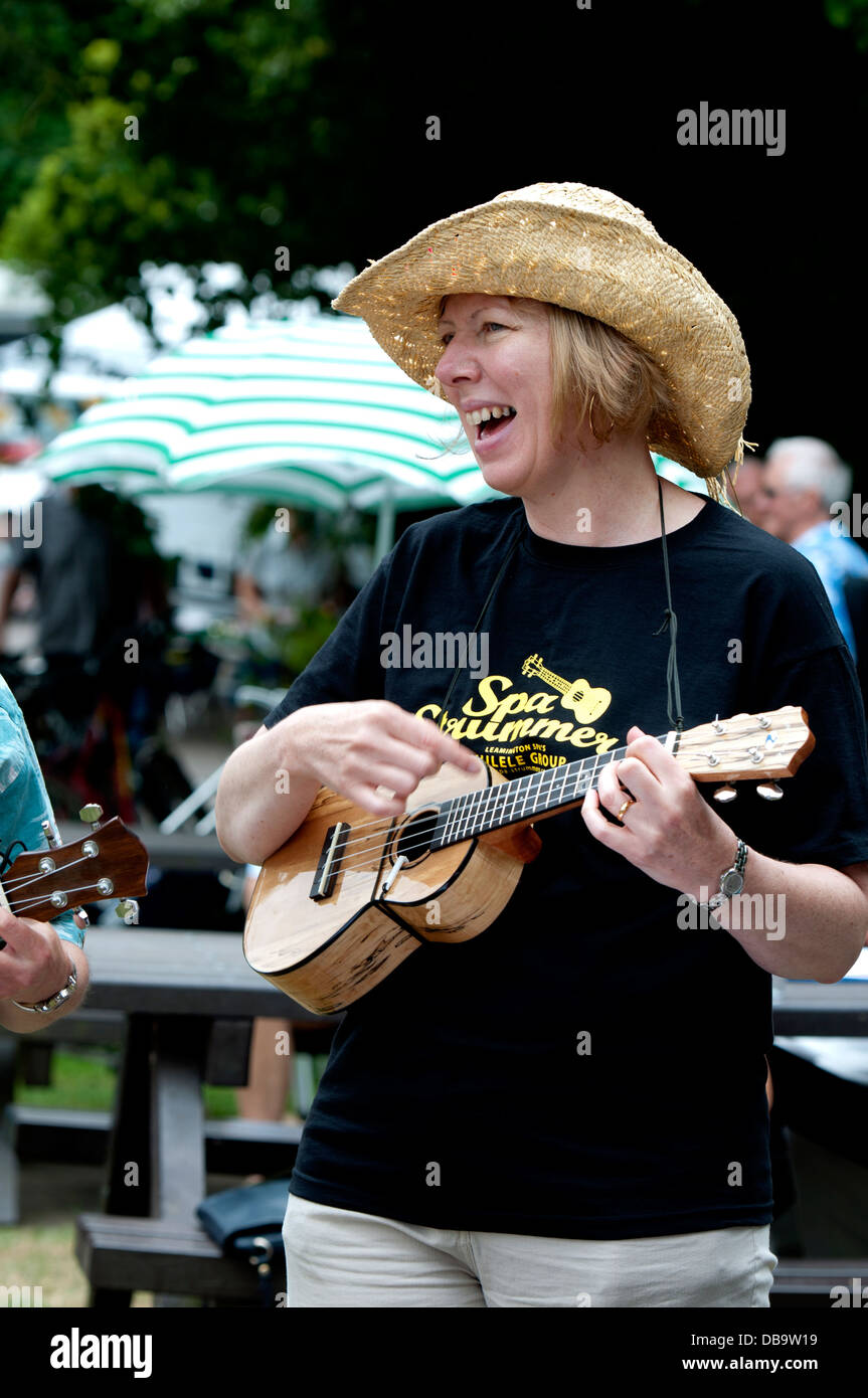 Woman singing and playing a ukulele Stock Photo - Alamy