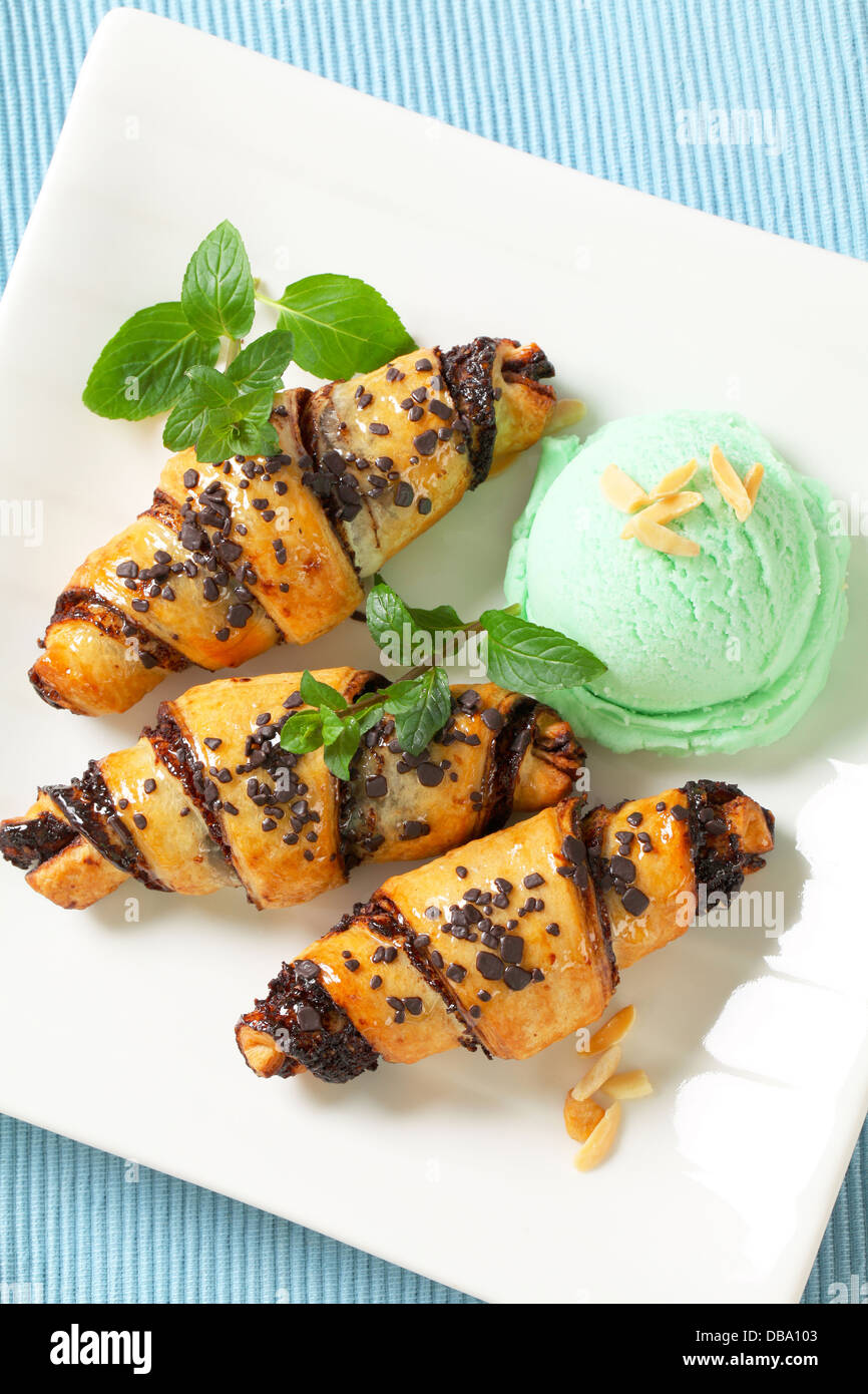 Chocolate-filled croissants and scoop of ice cream on plate Stock Photo ...