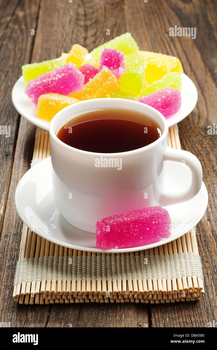 Cup of tea and colorful marmalade on wooden table Stock Photo - Alamy