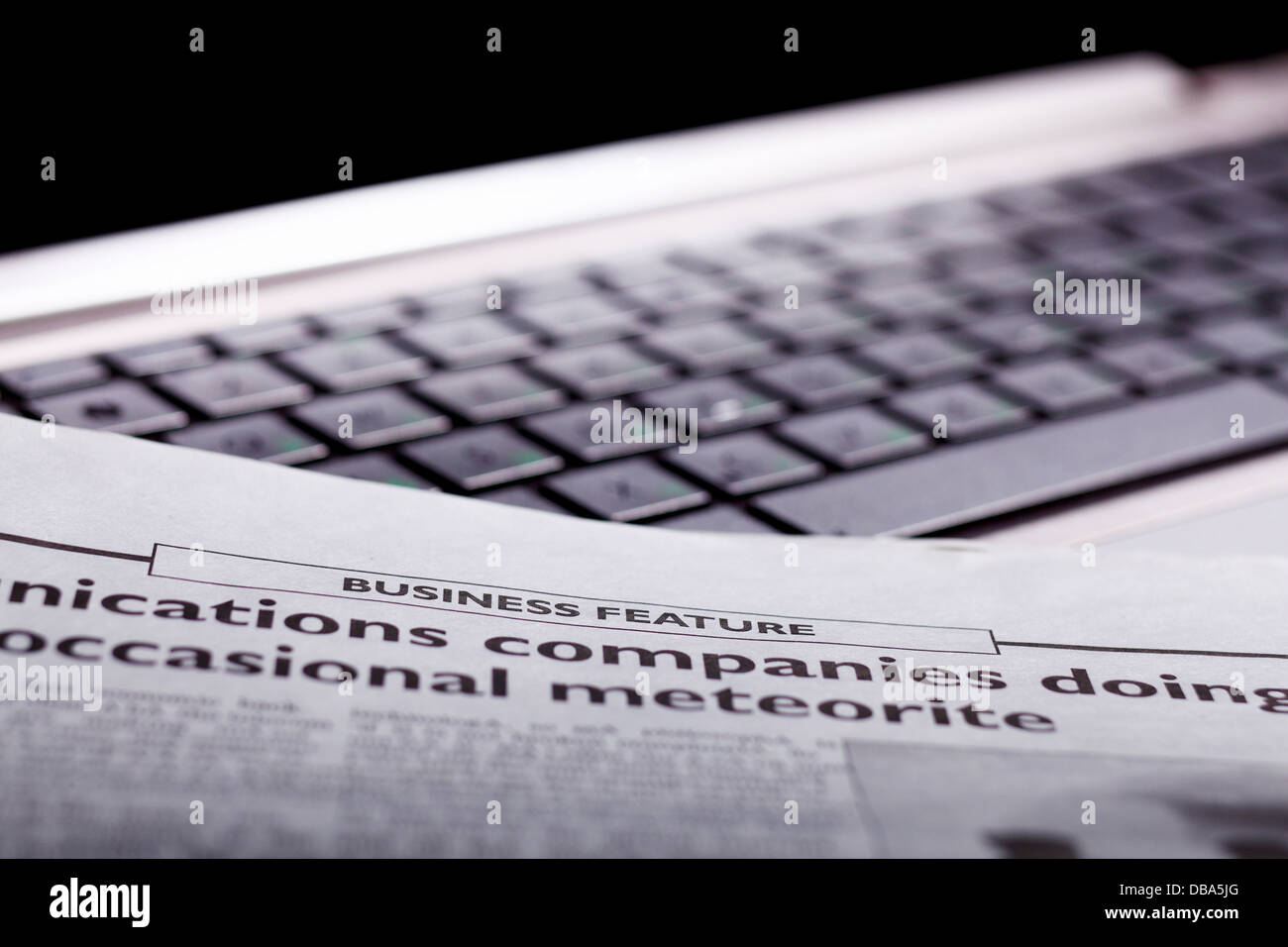 Notebook keyboard with a newspaper Stock Photo - Alamy