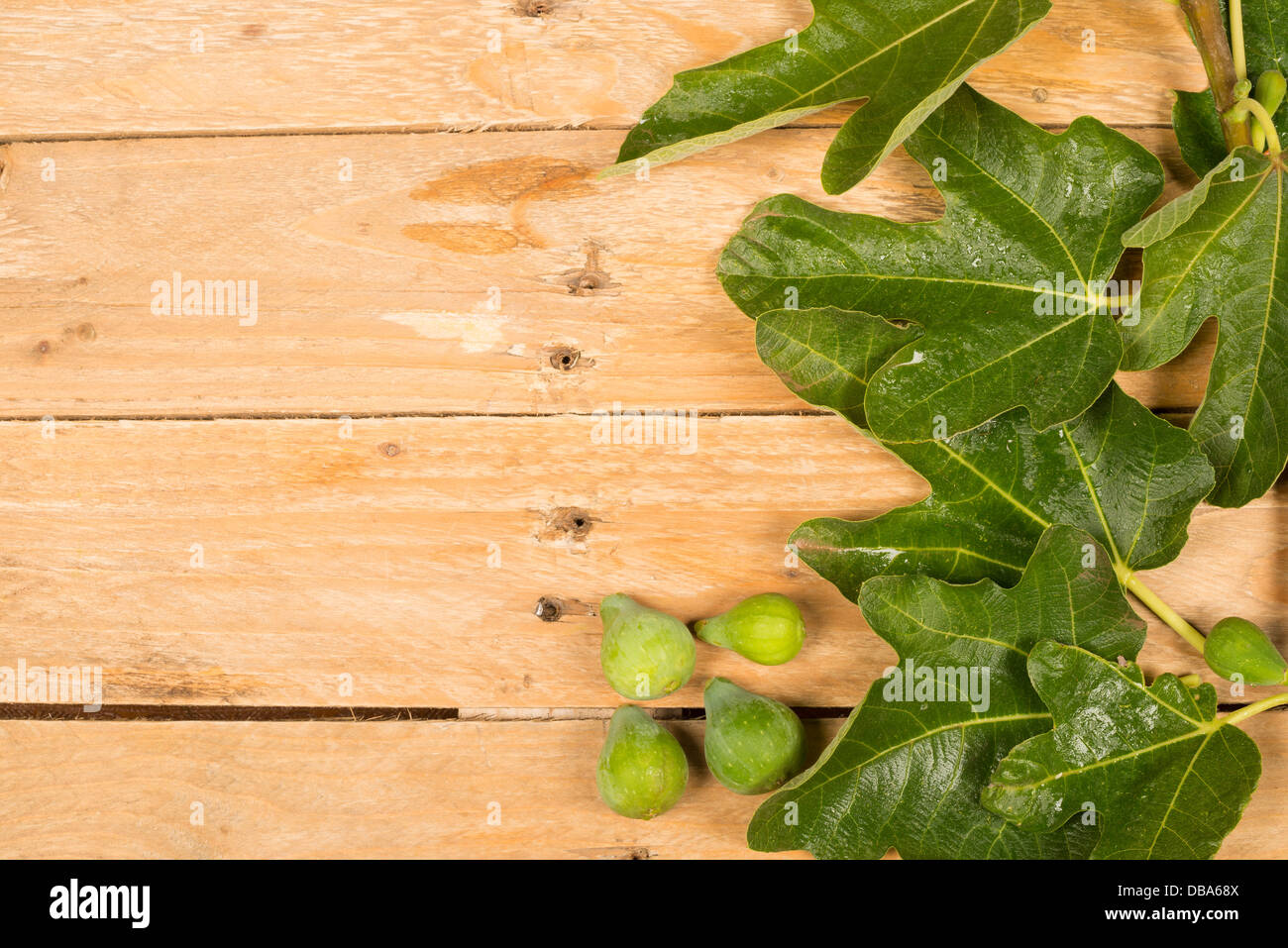 Freshly picked figs together with leaves on a wooden background Stock ...