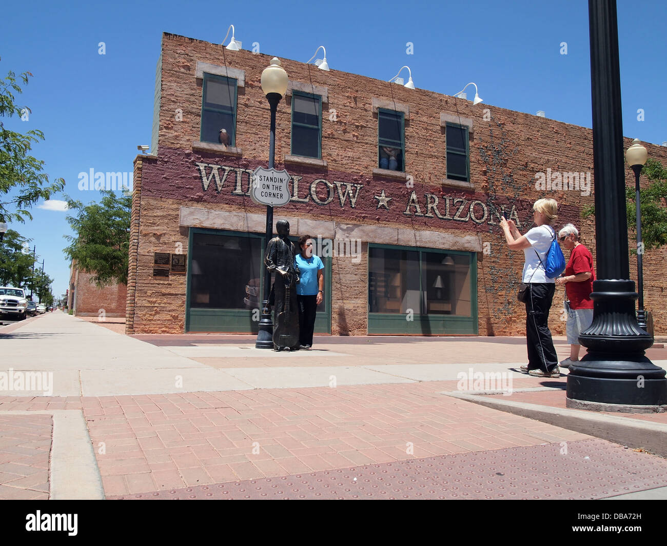 Tourists posing for photos with the bronze sculpture at Standin' On The ...