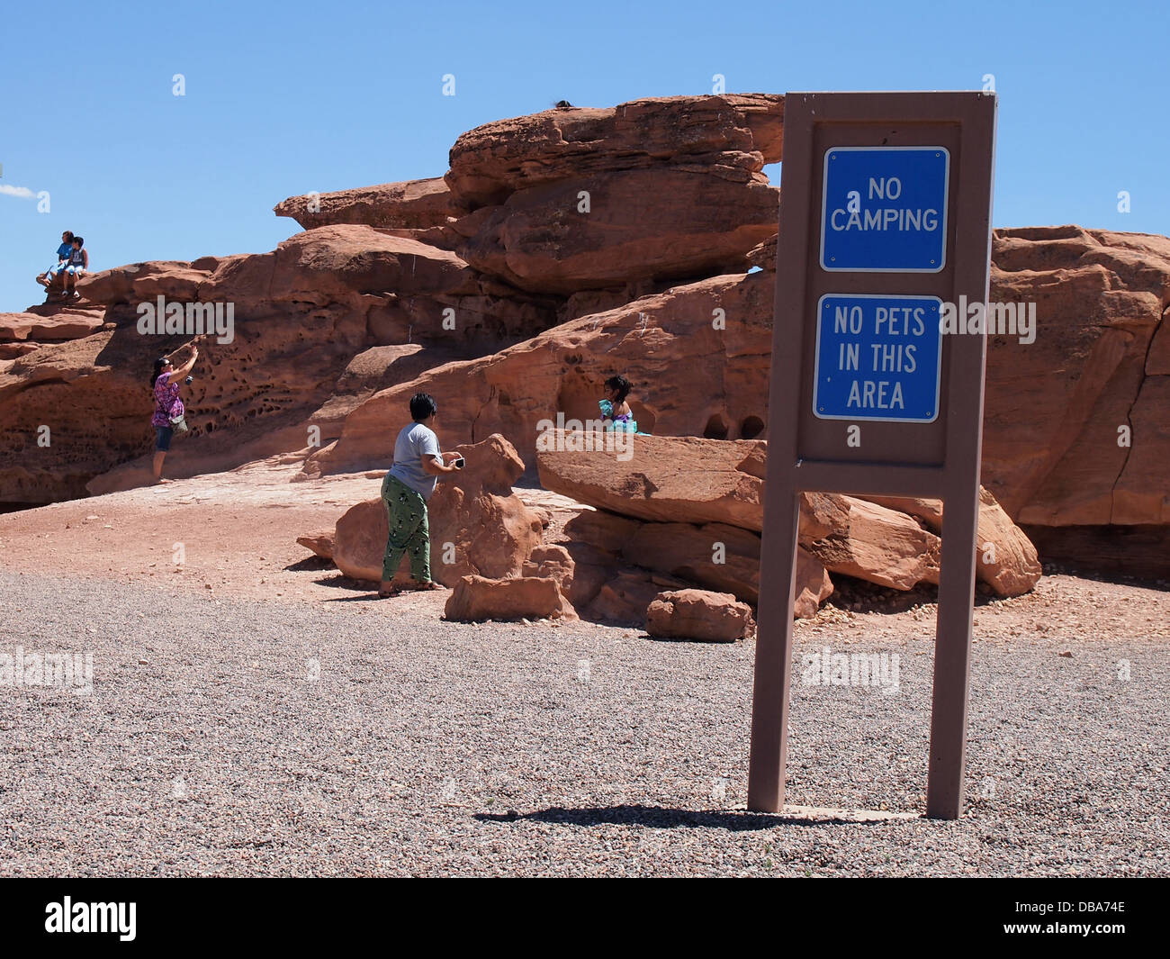 Tourists and their children at a red rock rest stop along Interstate 40 ...