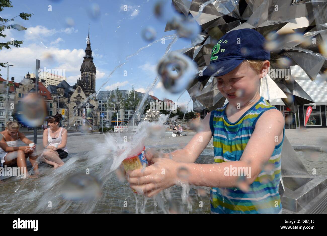 Six year-old Benjamin plays in a fountain in the tropical temperatures ...