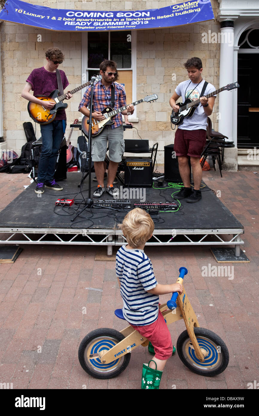 A boy on his bicycle watches local band Lemon Soul perform in Lewes ...